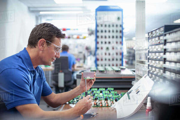 Electrical engineer assembling parts on production line in medical ...