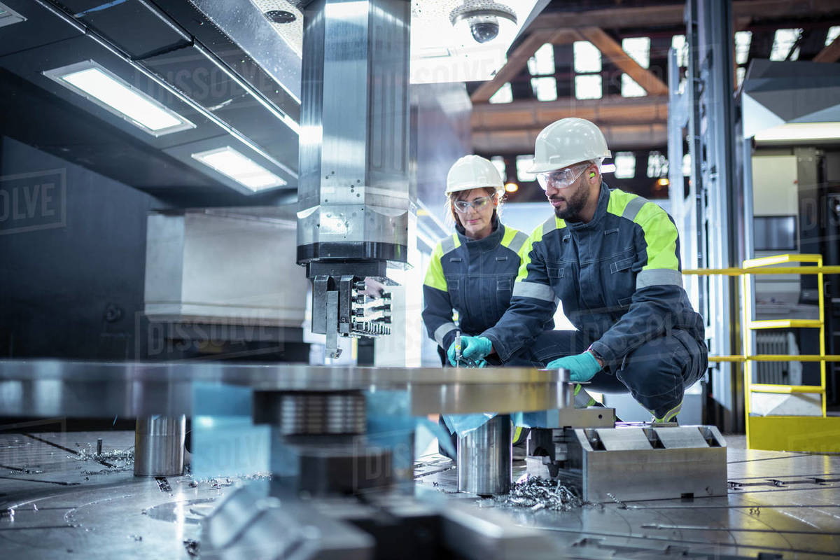 Male and female specialist lathe operators in steelworks - Royalty-free ...