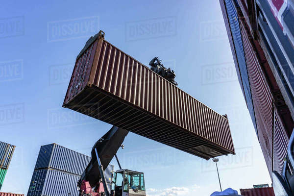 Reach stacker lifting shipping container in dock - Royalty-free Stock ...