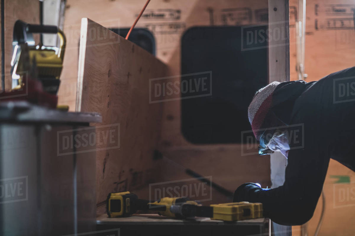Man wearing headlamp standing indoors, doing DIY. - Stock Photo - Dissolve