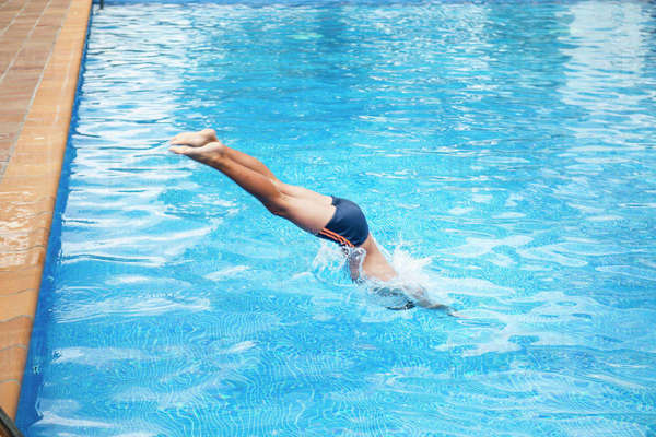 High angle view of boy diving into outdoor swimming pool. - Royalty ...