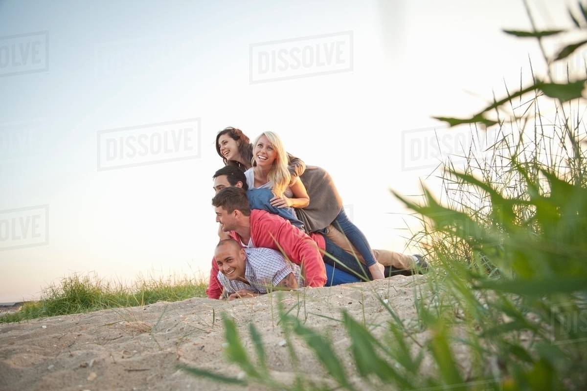 Group of friends making human pile on beach - Royalty-free Stock Photo ...