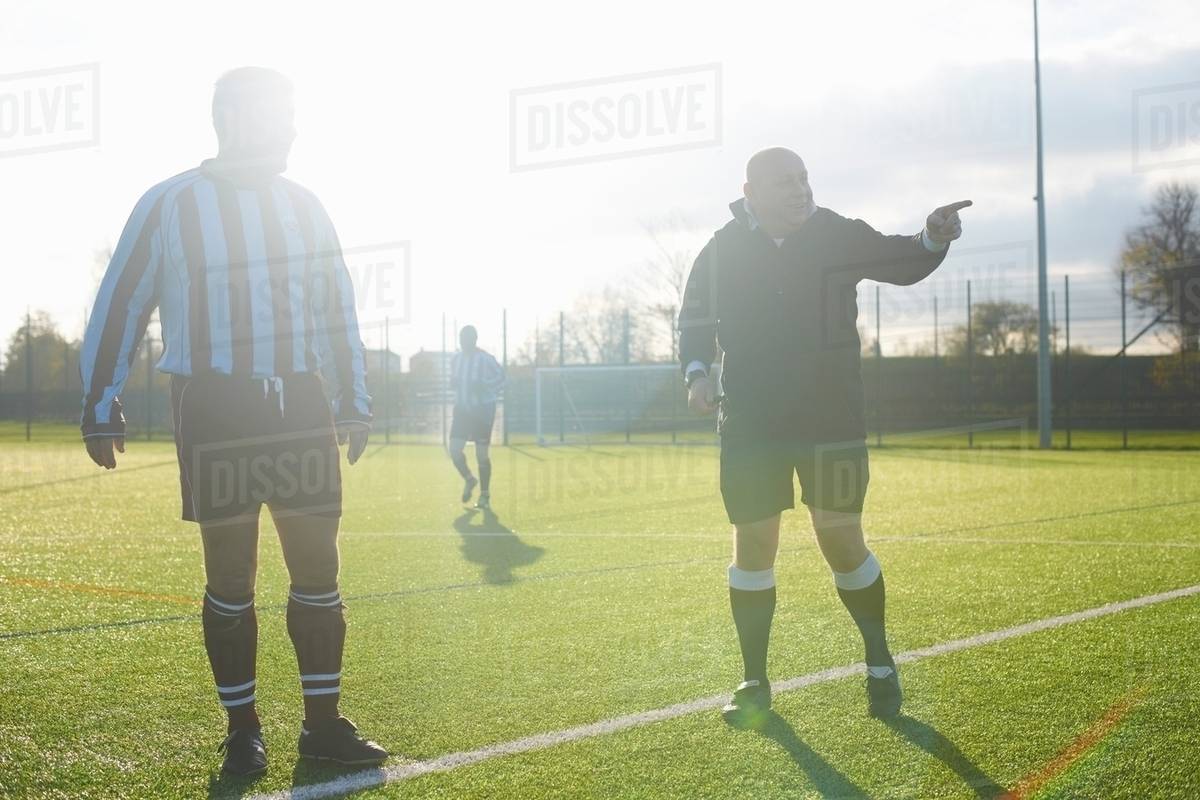 Football players starting game - Royalty-free Stock Photo | Dissolve