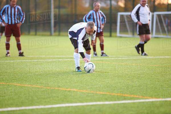 Football player positioning ball - Royalty-free Stock Photo | Dissolve