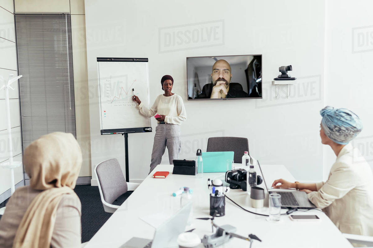 Businesswoman giving presentation to colleagues in office and over ...