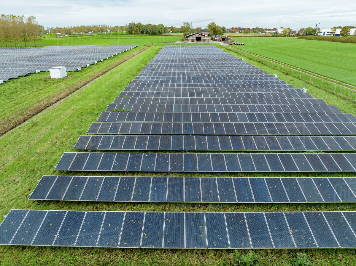 Expansive solar farm under a cloudy sky - Stock Photo - Dissolve