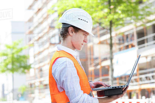 Engineer with helmet working outside new building - Stock Photo - Dissolve