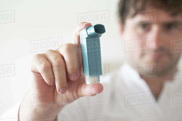 Doctor male holding an asthma spray in hishand - Stock Photo - Dissolve