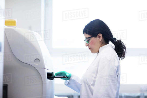 Scientist operating advanced laboratory equipment - Stock Photo - Dissolve
