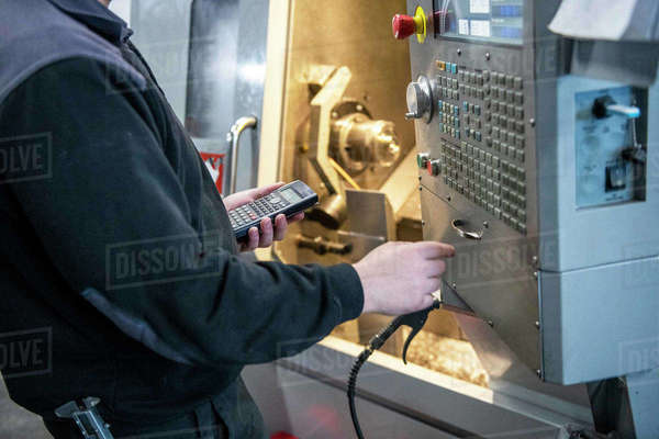 Young mechanical engineer working on steel machinery in a factory ...