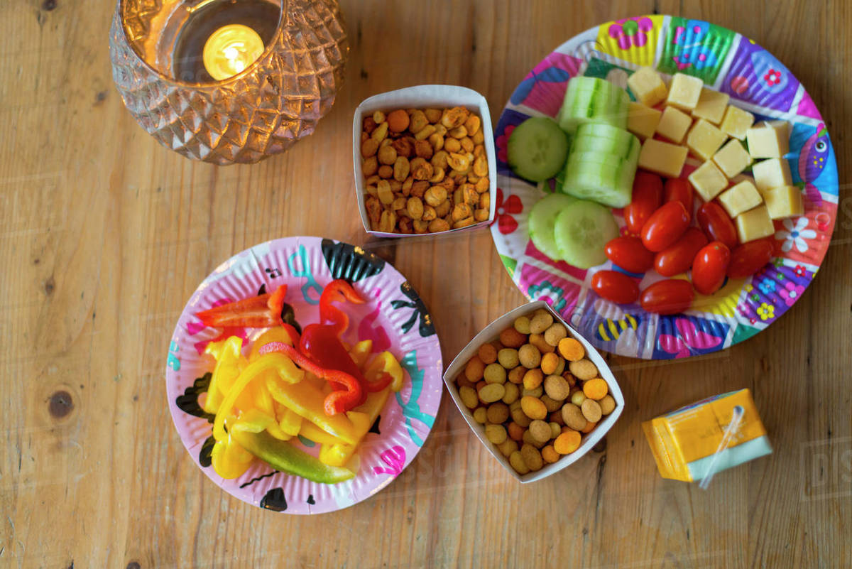 Cozy snack spread on a rustic wooden table with a lit candle. - Stock ...