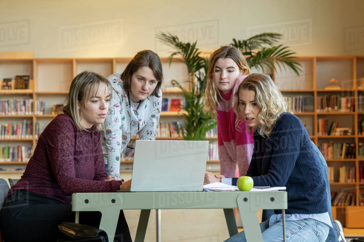 A group of engaged women collaborating on a project while gathered ...