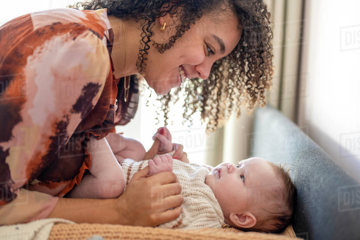 A heartwarming moment as a mother smiles lovingly at her baby. - Stock ...