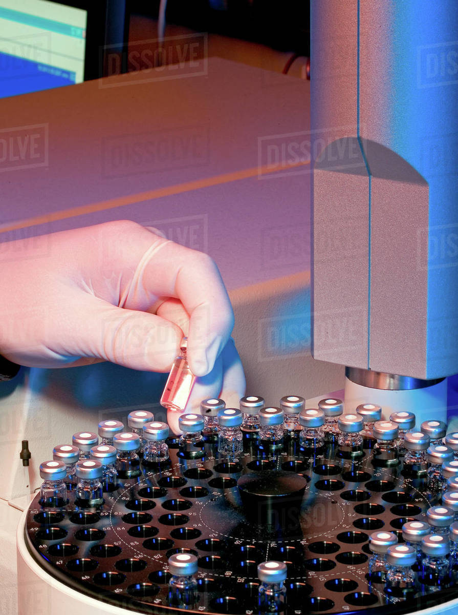 Scientist loading samples into an analytical machine - Stock Photo ...