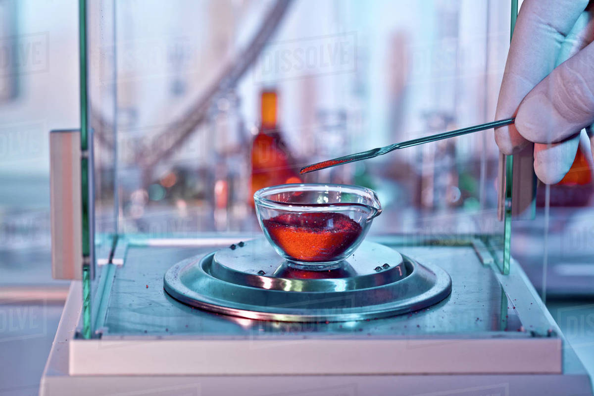 Scientist conducting an experiment with a vibrant red substance in a ...