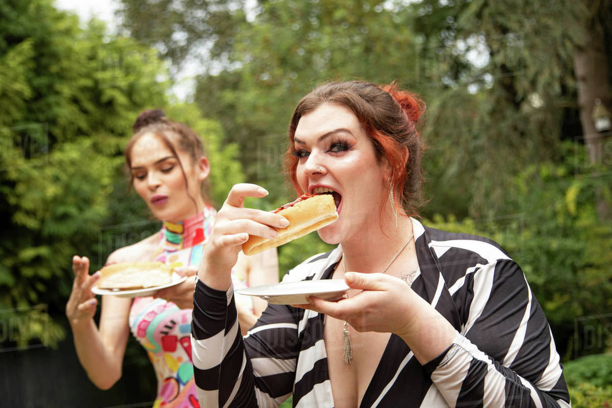 Two young Trans Women having fun and eating party food and enjoying a ...