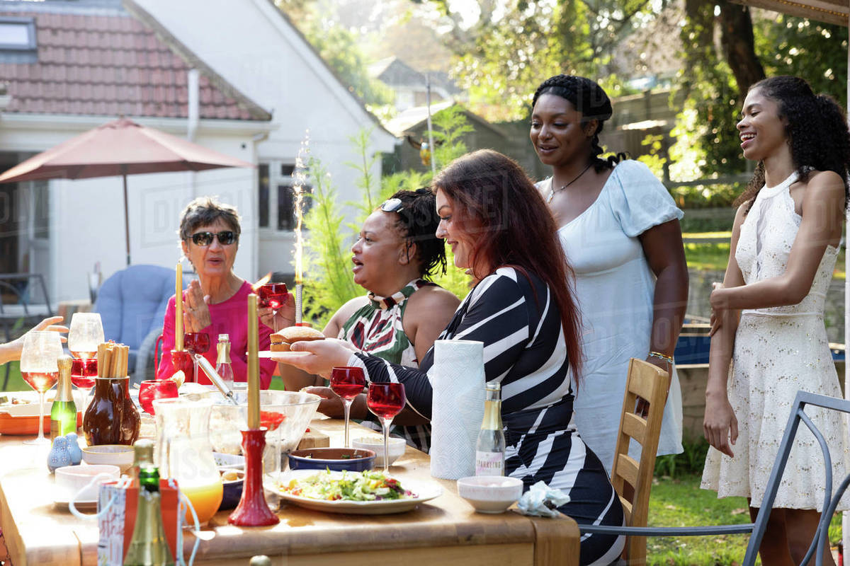 A mixed gathering of women laughing and having fun at a summer garden ...