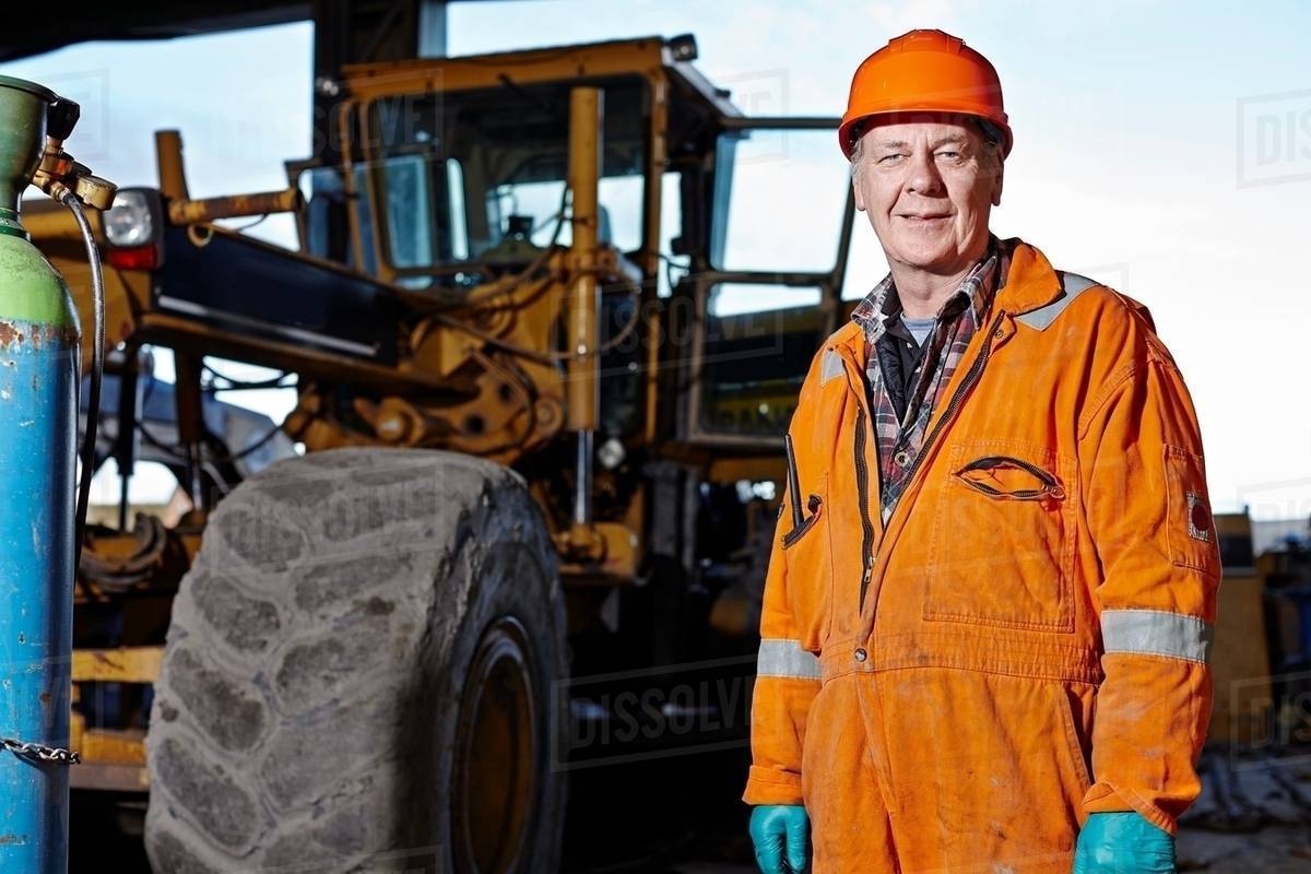 Portrait of quarry worker next to excavator at quarry site - Royalty ...