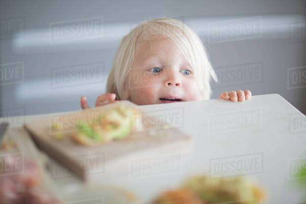 Boy peeking over kitchen counter - Royalty-free Stock Photo | Dissolve