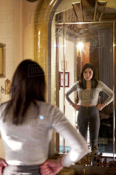 A person is standing in front of a mirror, with their reflection ...