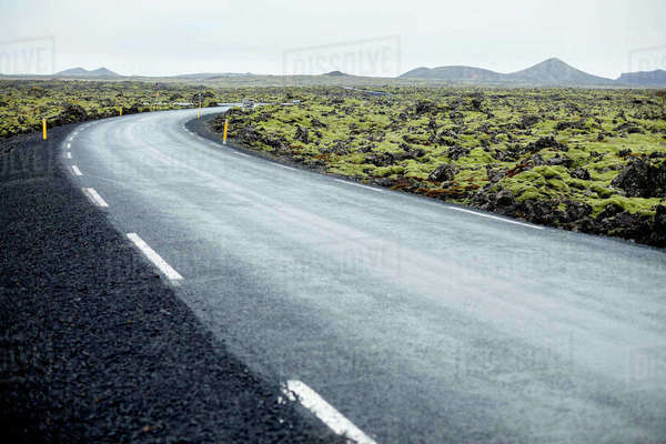 A person enjoys a scenic overlook next to a car, gazing out over a vast ...