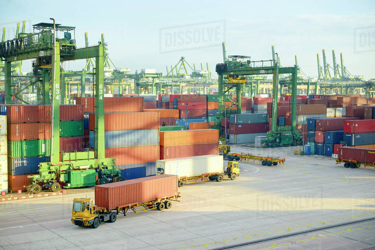 Container terminal at dusk with automated guided vehicles and stacked ...