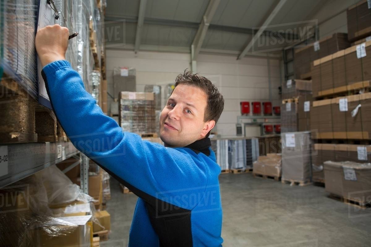 Factory worker checking pallets - Royalty-free Stock Photo | Dissolve