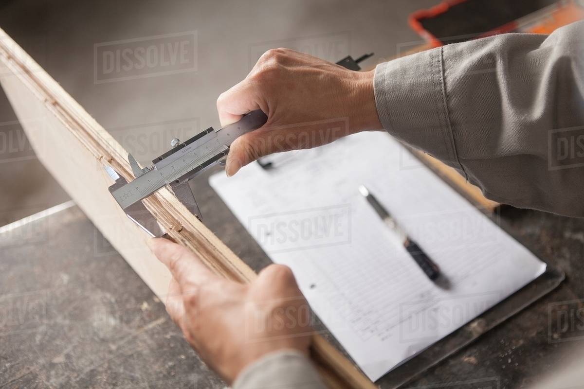 Carpenter measuring wood plank with vernier caliper in factory, Jiangsu ...