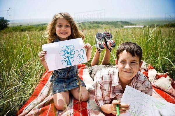 Two children showing their drawings - Royalty-free Stock Photo | Dissolve