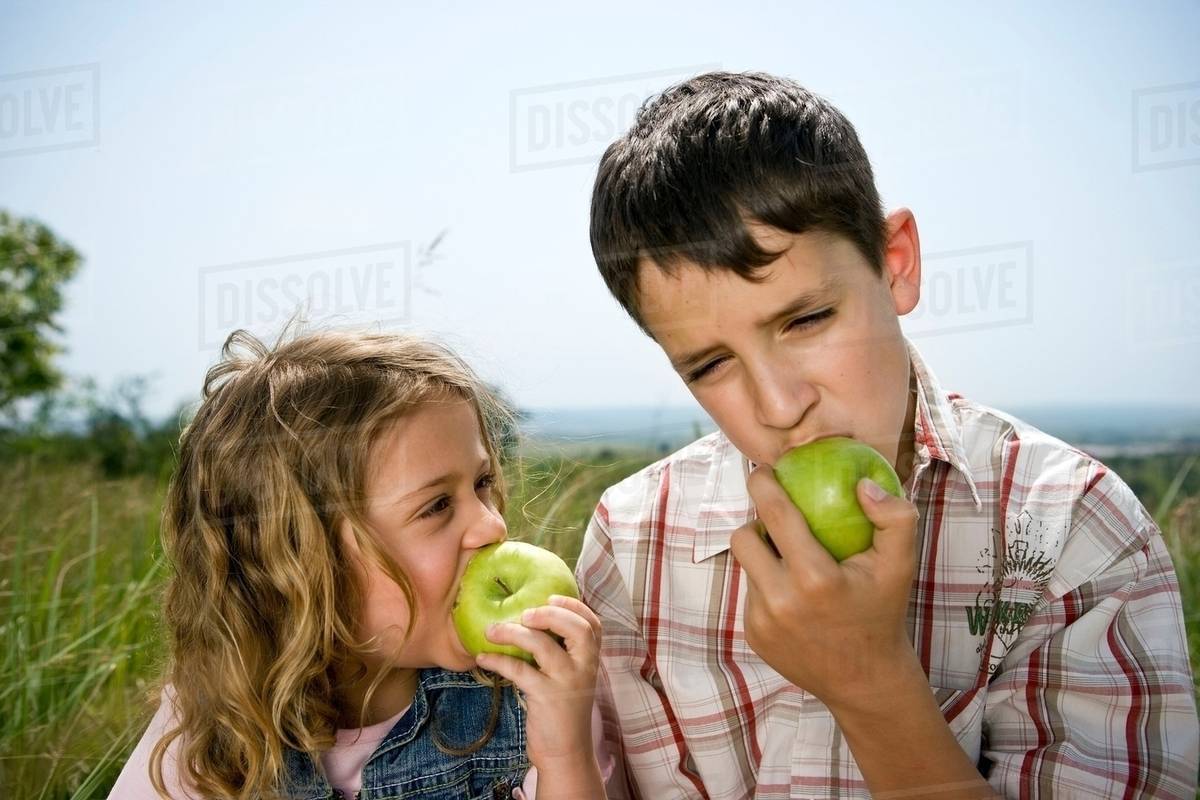 Children eating apples - Royalty-free Stock Photo | Dissolve
