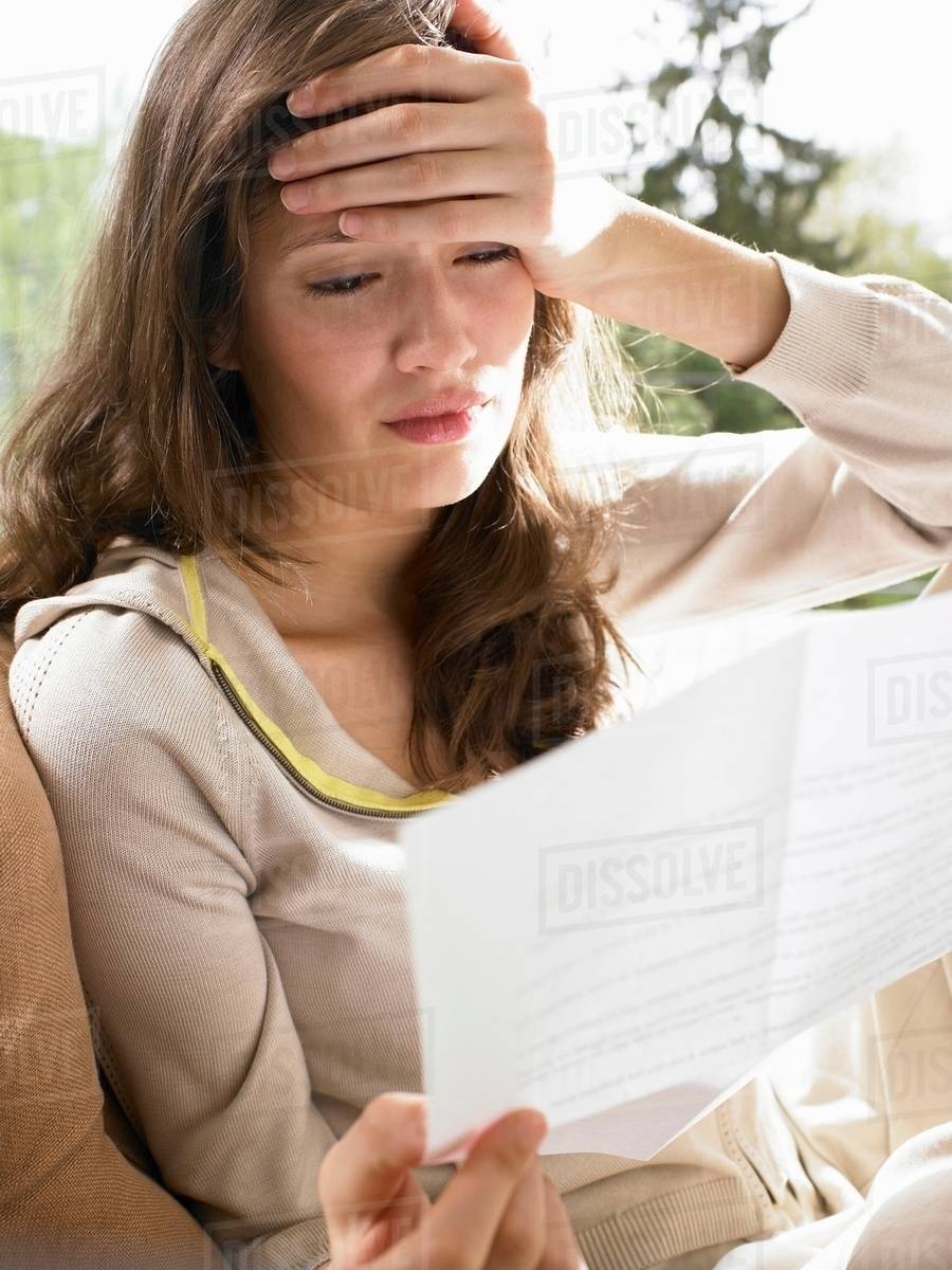 Young woman reading a letter - Stock Photo - Dissolve
