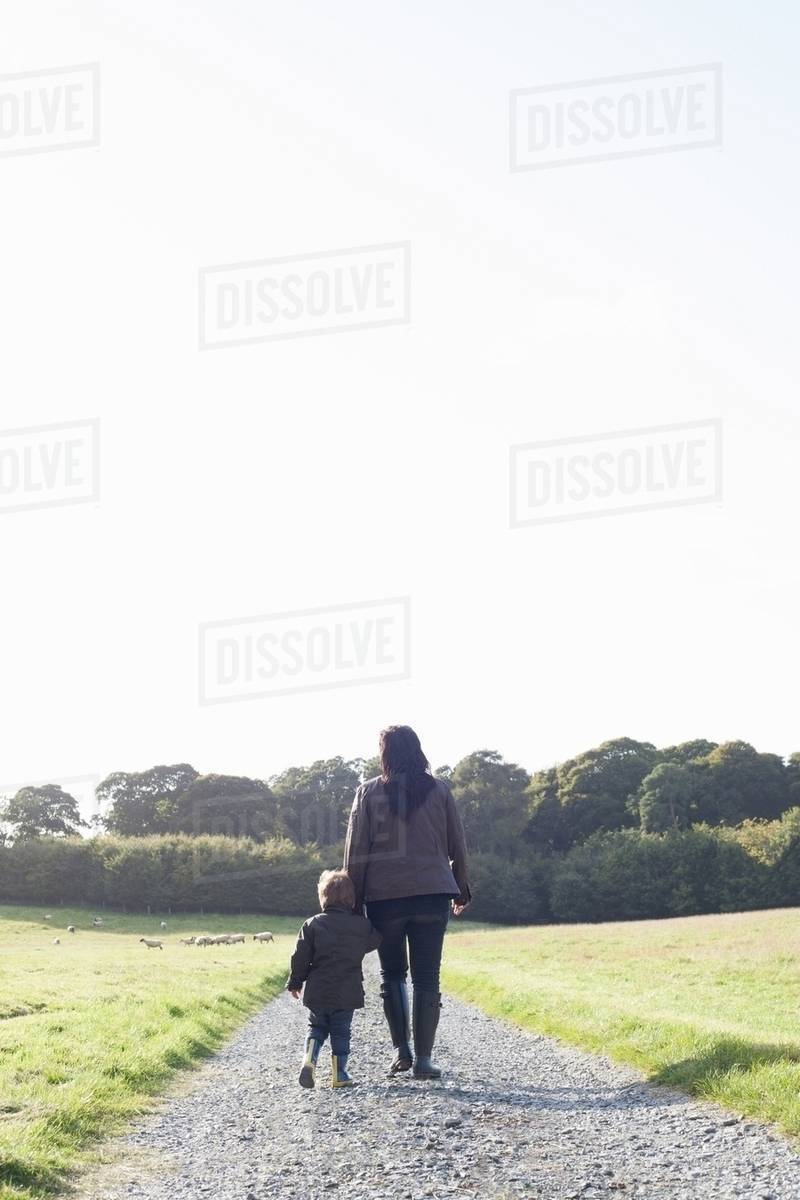 Mother and son walking on dirt road - Royalty-free Stock Photo | Dissolve