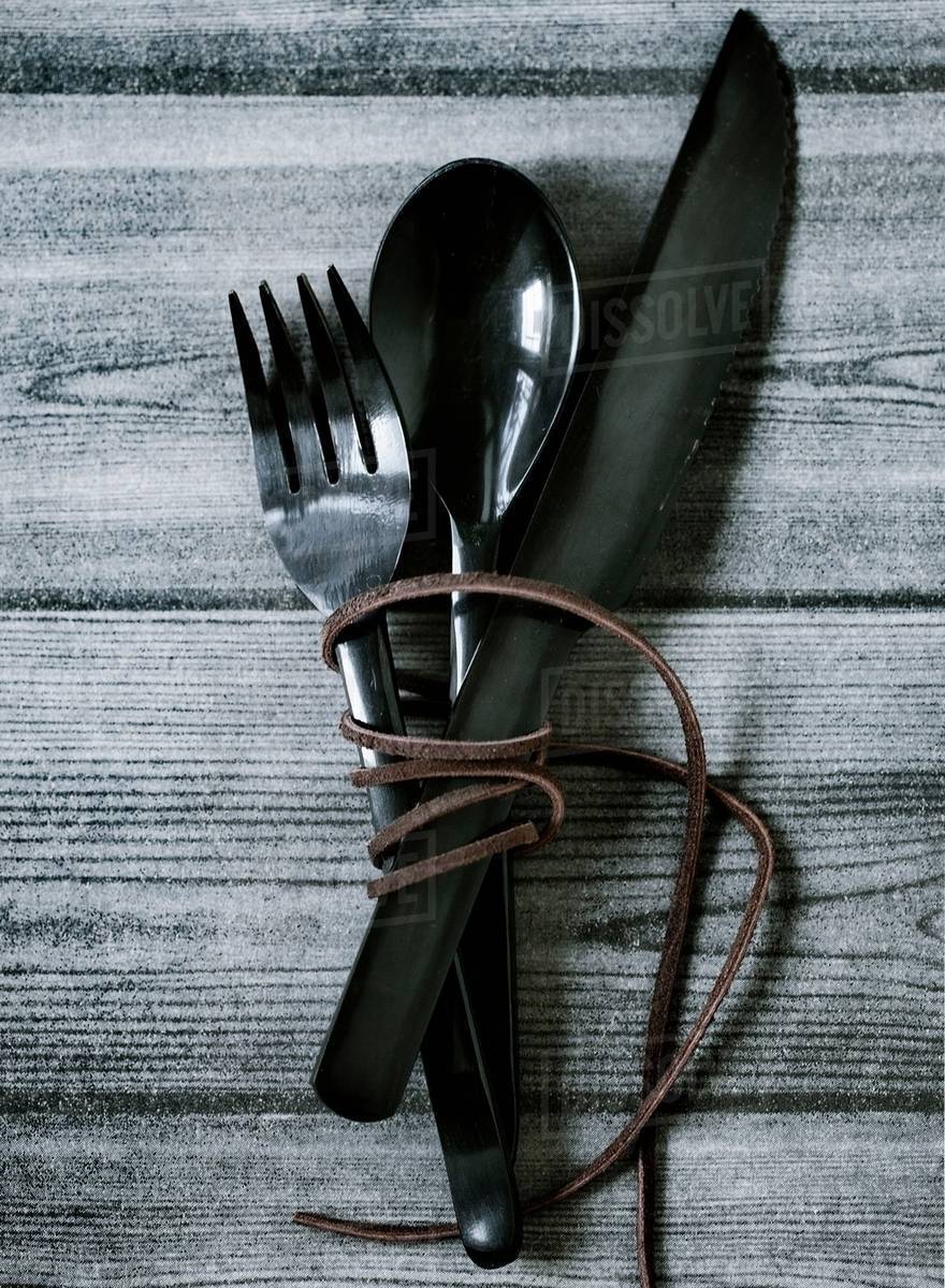 Wrapped cutlery on wooden table - Royalty-free Stock Photo | Dissolve