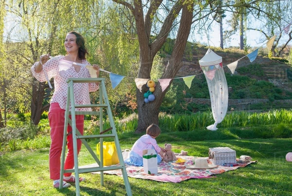 Woman hanging bunting outdoors - Royalty-free Stock Photo | Dissolve
