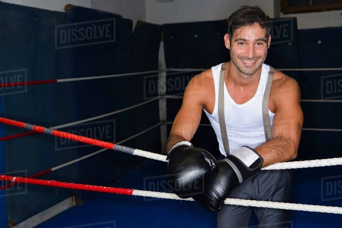 Smiling boxer standing in ring - Stock Photo - Dissolve
