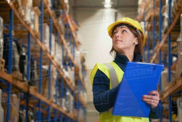 Worker checking stock in warehouse - Stock Photo - Dissolve