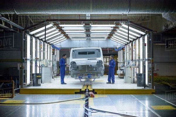 Workers and vehicle in inspection station in car factory - Stock Photo ...