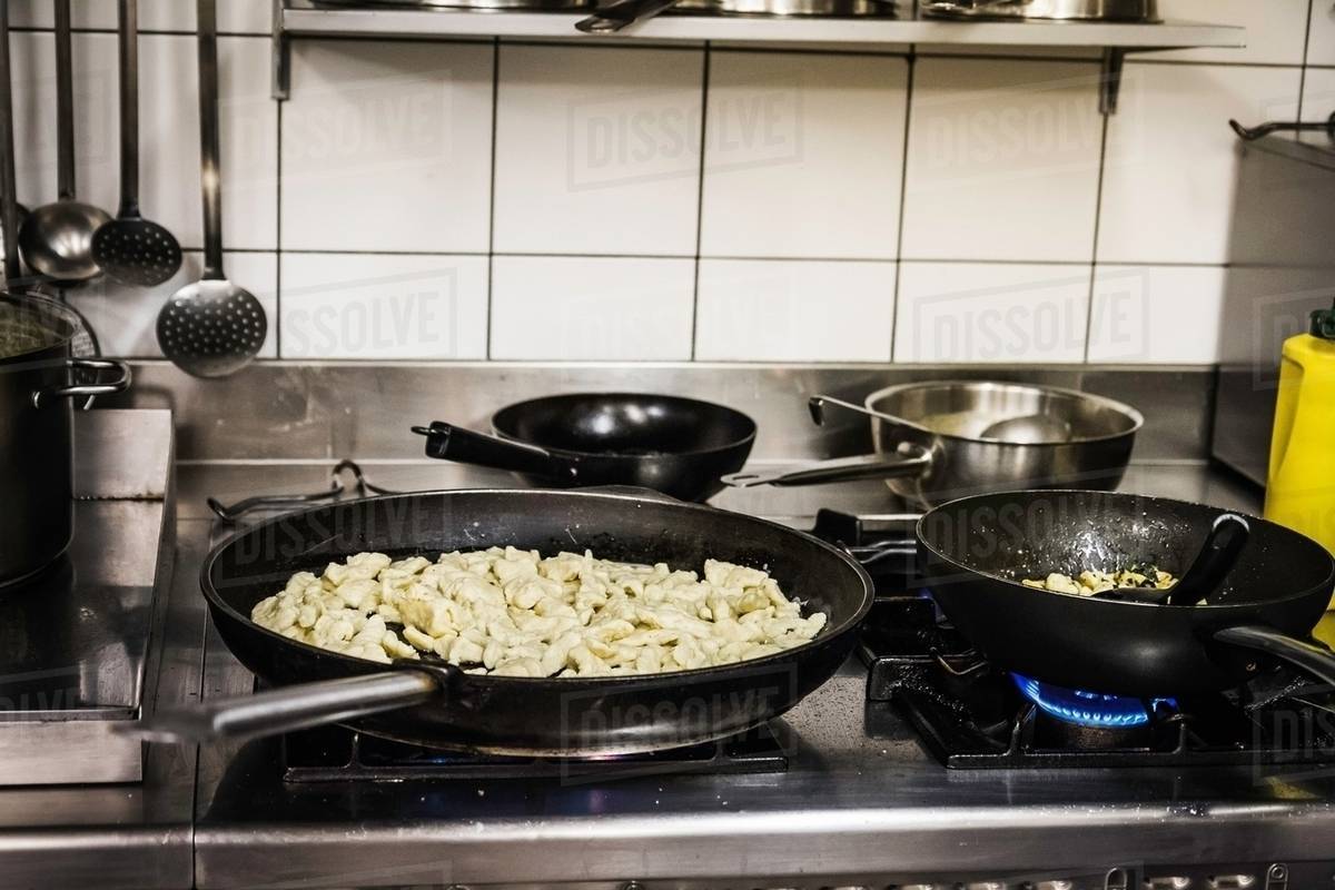 Pans of food cooking on stove - Royalty-free Stock Photo | Dissolve