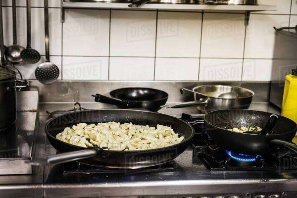 Pans of food cooking on stove - Royalty-free Stock Photo | Dissolve