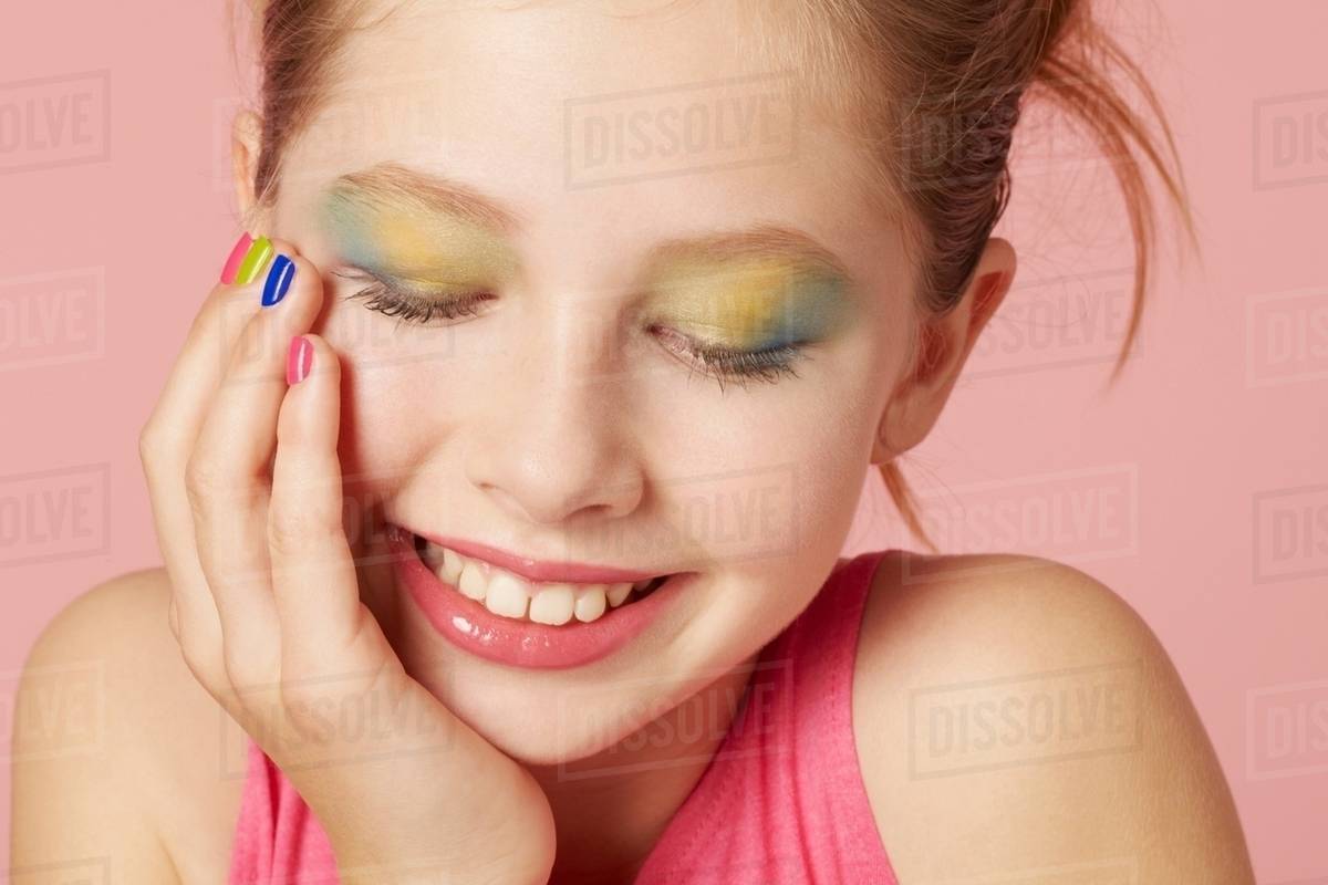Smiling girl wearing colorful makeup - Stock Photo - Dissolve