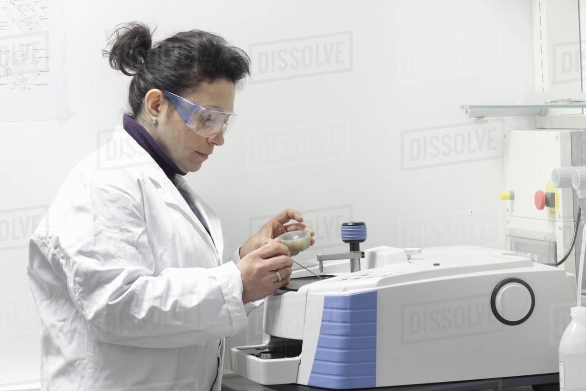 Scientist using machinery in lab - Stock Photo - Dissolve
