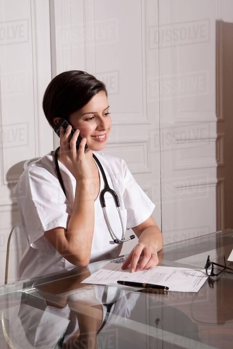 Doctor talking on cell phone in office - Royalty-free Stock Photo ...