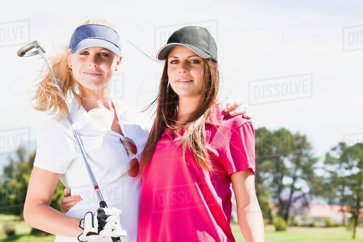 Women smiling together on golf course - Stock Photo - Dissolve