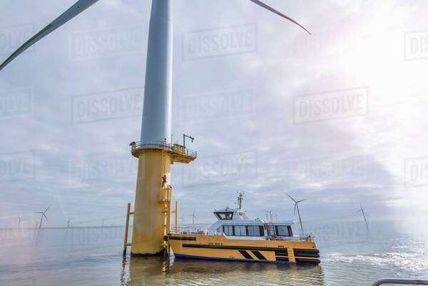 Service boat and wind turbine at offshore windfarm - Stock Photo - Dissolve