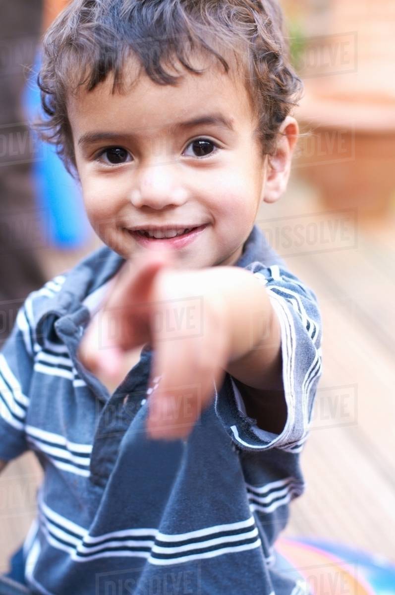 Smiling boy pointing forward - Royalty-free Stock Photo | Dissolve