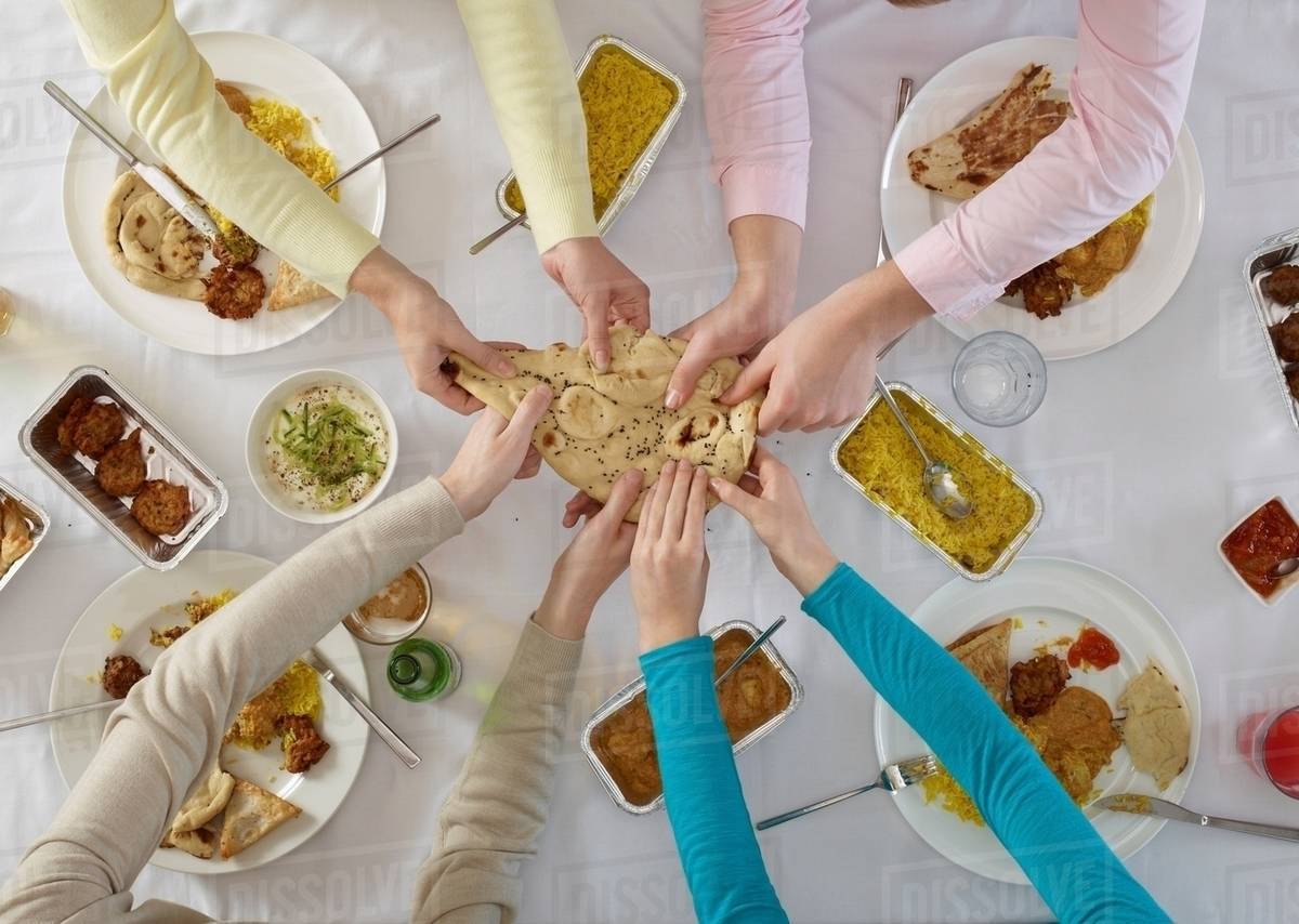 Overhead view of people sharing at table - Stock Photo - Dissolve