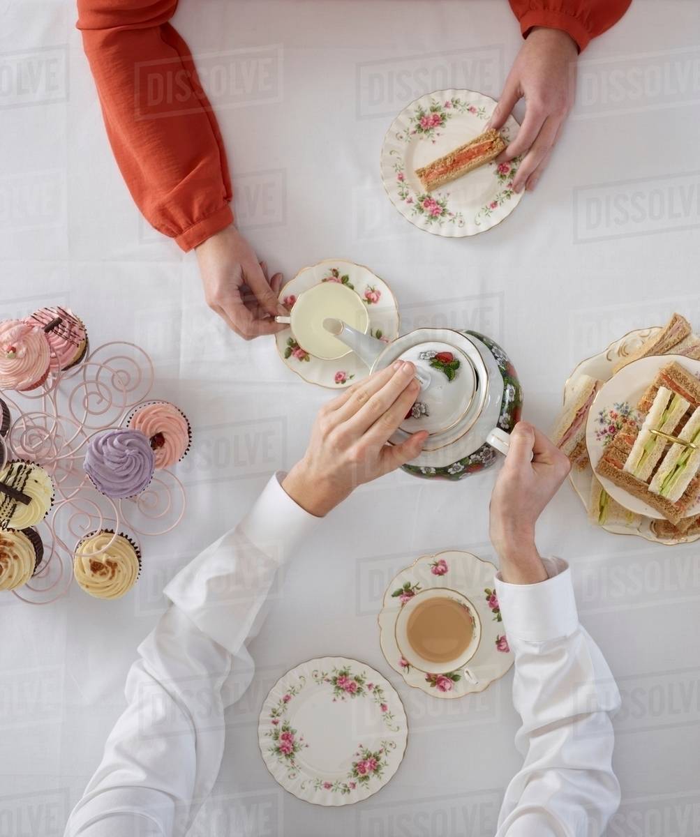 Overhead view of people having tea - Stock Photo - Dissolve