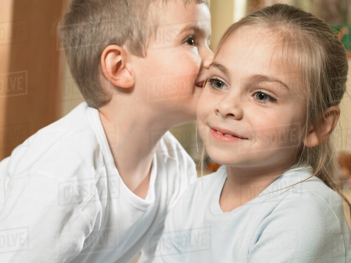 Boy whispering in girls ear - Royalty-free Stock Photo | Dissolve