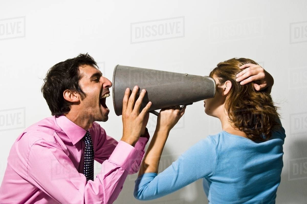 Businessman shouting into colleagues ear - Stock Photo - Dissolve