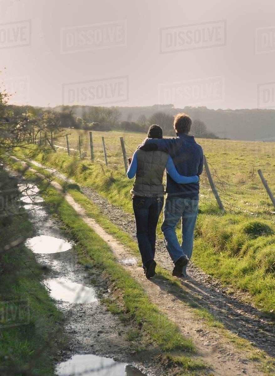 Couple walking on rural road - Royalty-free Stock Photo | Dissolve